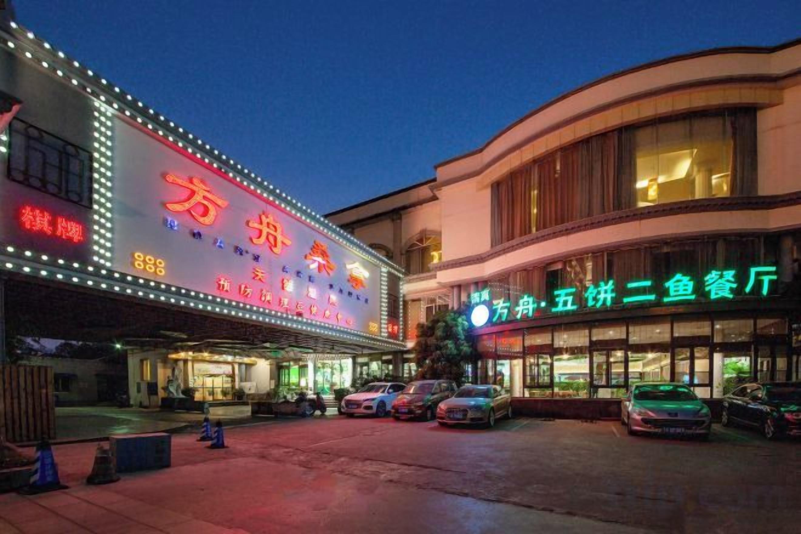 Um teatro com toldo luminoso e restaurante ao lado.