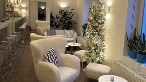 Um interior moderno com poltronas confortáveis, um pinheiro de Natal alto e um bar com banquetas.