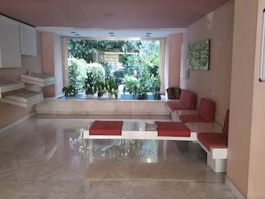 Sala de estar moderna com um sofá, uma mesa de centro e vista para o verde lá fora.