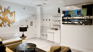 Uma sala de estar moderna com um sofá, uma mesa de centro e uma televisão fixada na parede.