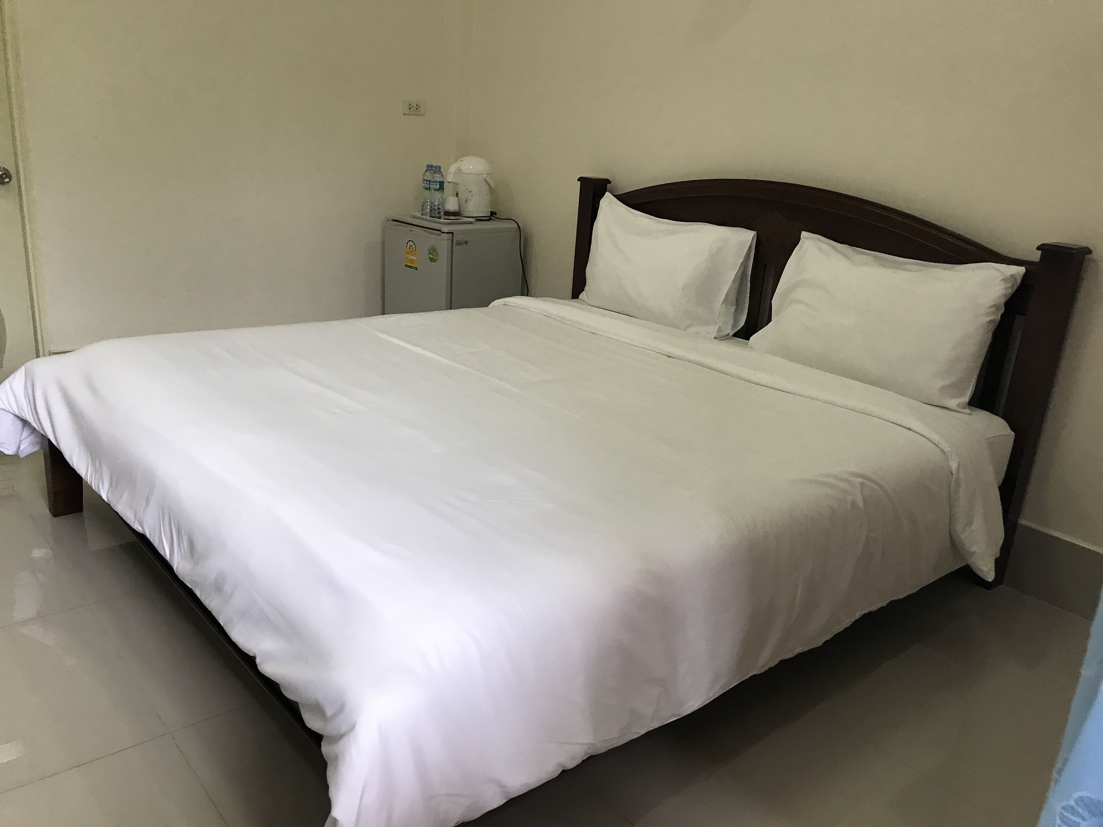 Cama bem arrumada com lençóis brancos em um quarto de hotel.