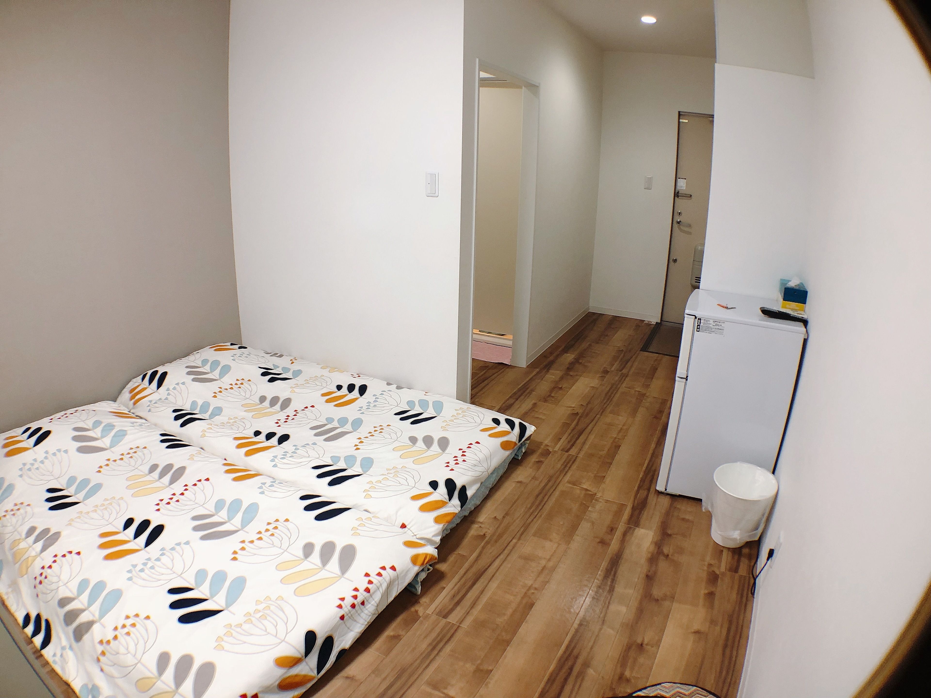 Quarto pequeno e limpo com uma cama, frigorífico e sanita.