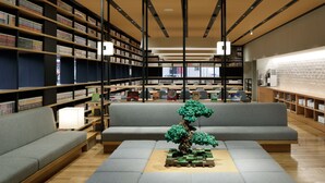 Uma biblioteca moderna com estantes, áreas de estar e uma árvore ornamental central.