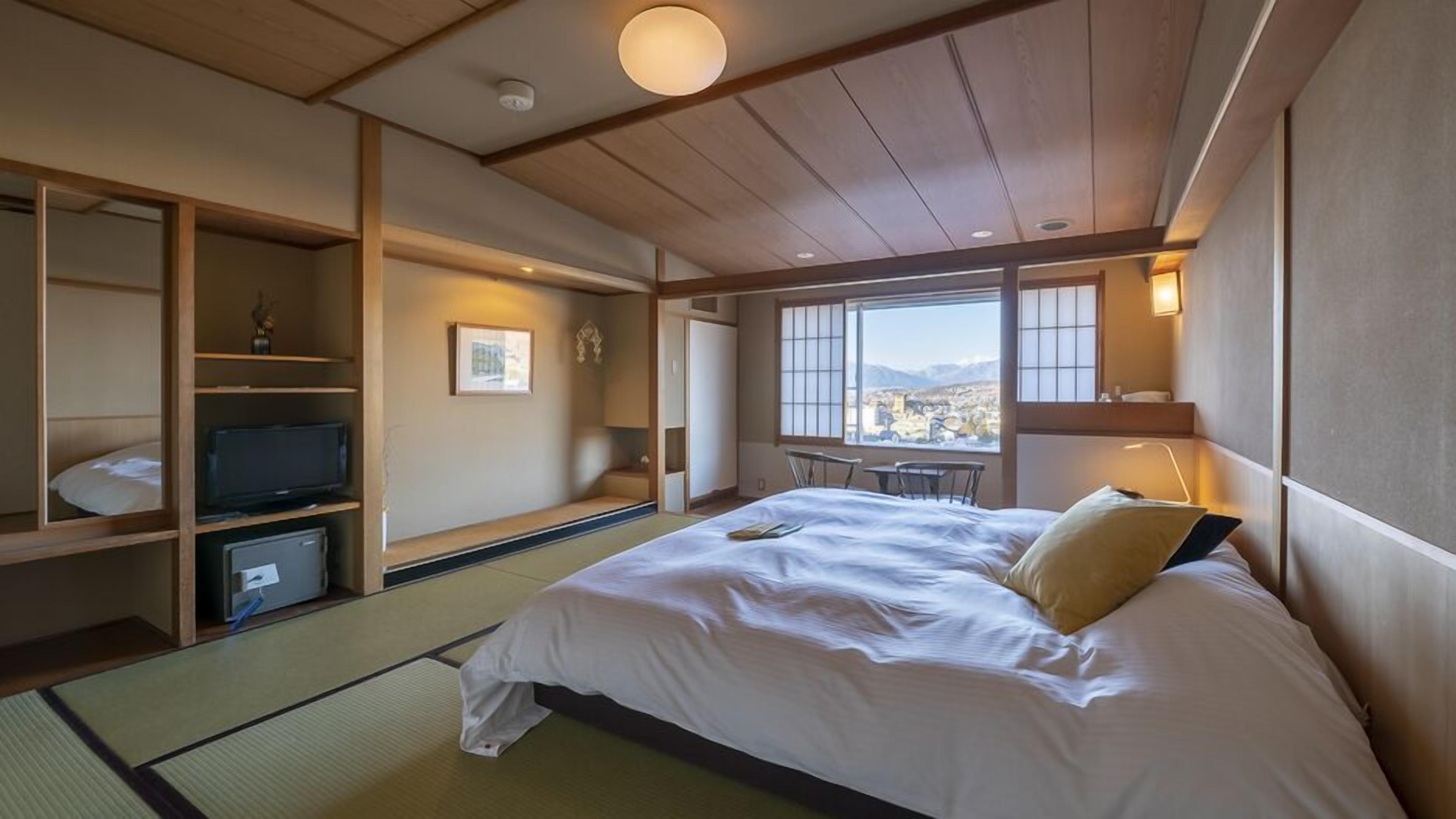 Quarto tradicional japonês com tatames, uma cama, uma televisão e vista para o horizonte urbano.