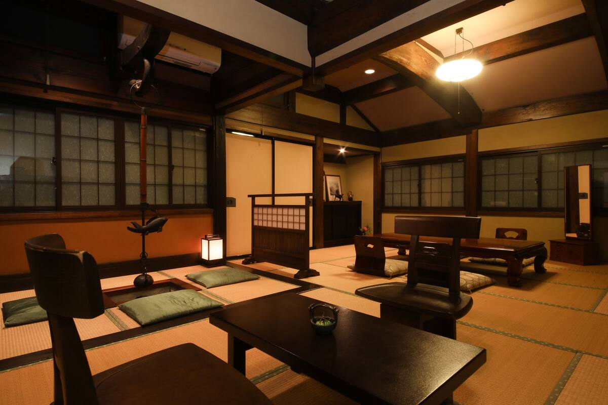 Um quarto japonês tradicional, com tatames, mesinhas baixas e almofadas.