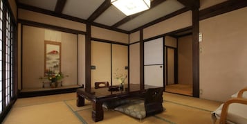 Um quarto japonês tradicional com tatames, uma mesa de madeira baixa e uma porta deslizante.