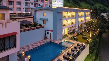 Um hotel com área de piscina, espaço para sentar ao ar livre e vista para um rio.