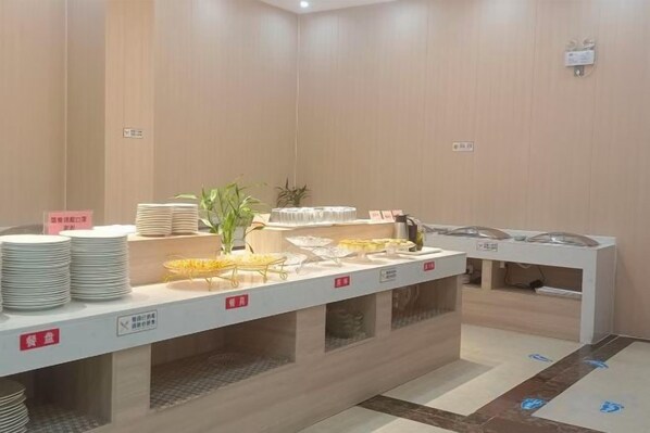 Disposição de buffet com várias estações de serviço, incluindo uma variedade de pratos e utensílios.