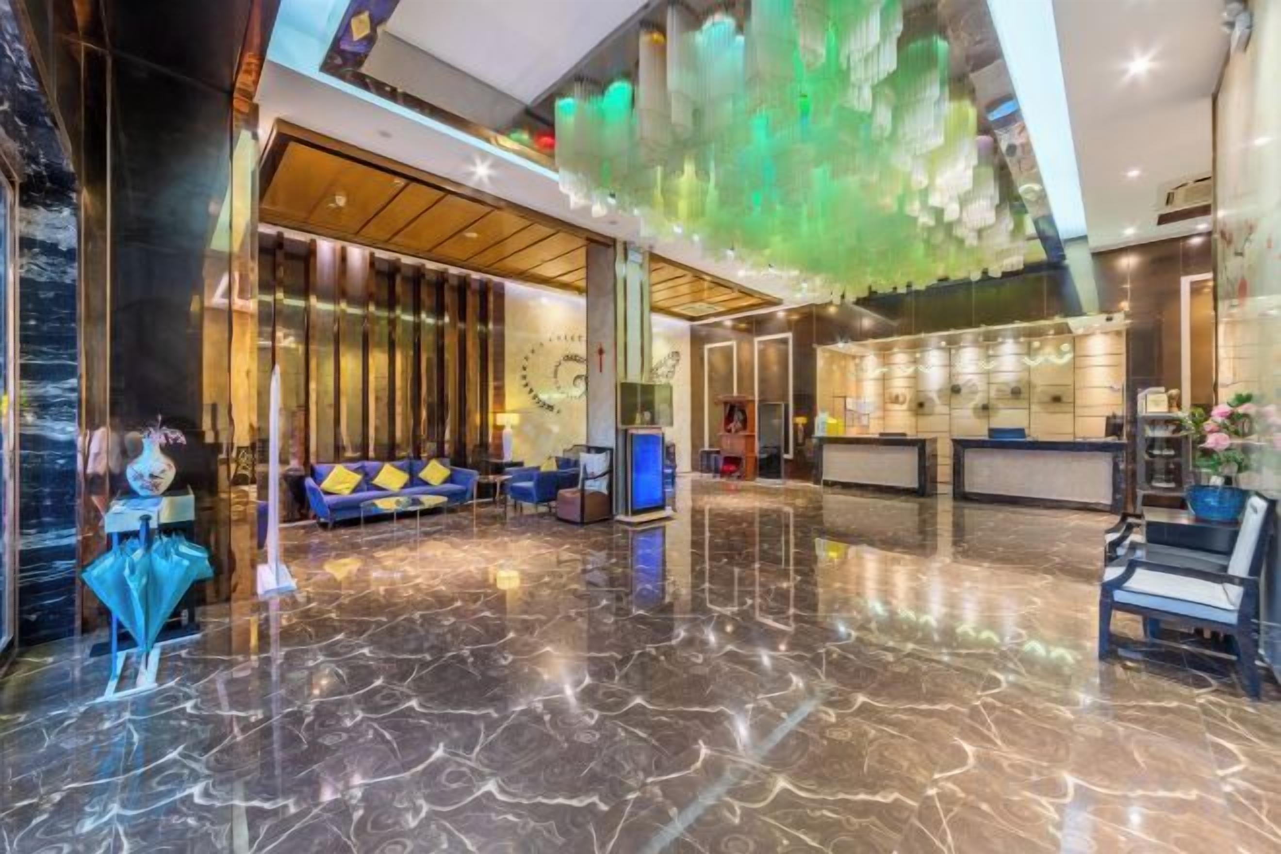 Um hall de hotel com piso de mármore, área de estar, balcão de recepção e design moderno no teto.