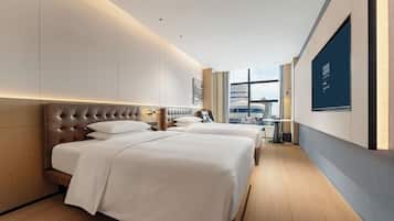 Quarto de hotel moderno com duas camas, uma janela grande e vista da cidade.