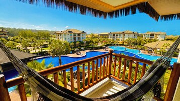 Um resort com uma grande piscina, vários edifícios e vegetação exuberante.