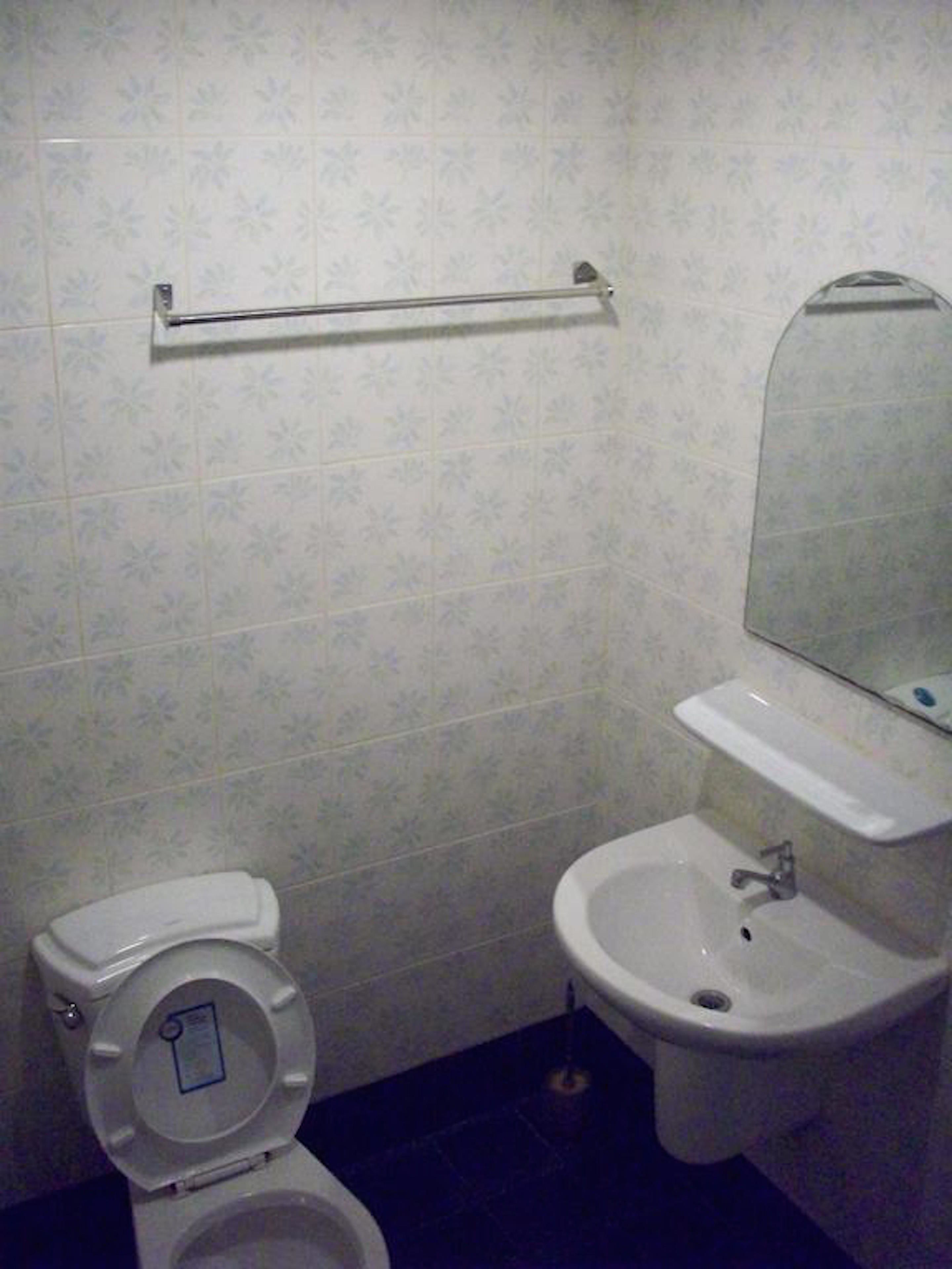 Uma casa de banho standard com sanita, bidé e um espelho sobre a lavatório.