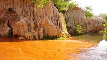 Paisagem natural com margem de rio e formações rochosas.