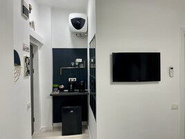 Uma casa de banho moderna com lavatório preto, espelho, sanita e zona de duche.