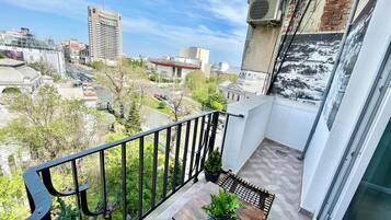 Uma varanda com vista para a paisagem urbana, incluindo edifícios e árvores.