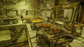 Disposição de buffet com várias estações de serviço e bancada de mármore.