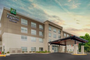 Edifício Holiday Inn Express & Suites com design moderno, fachada plana, grandes janelas e entrada coberta.