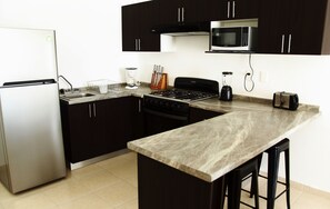 Um frigorífico, um micro-ondas, um forno, uma placa de cozinha 