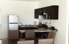 Um frigorífico, um micro-ondas, um forno, uma placa de cozinha 