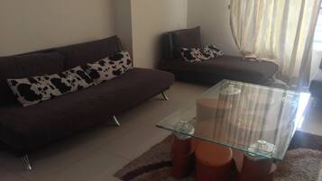 Apartamento Deluxe, 3 quartos | Sala | Televisor