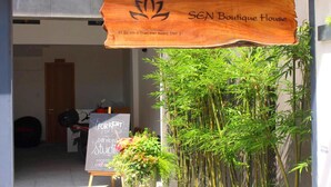 Placa de madeira da SEN Boutique House com um símbolo de lótus, localizada na 51 Str. No. 2 Thao dien Award, Distrito 2.