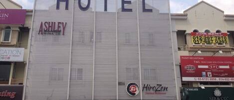 Um hotel com uma grande placa indicando "HOTEL ASHLEY".