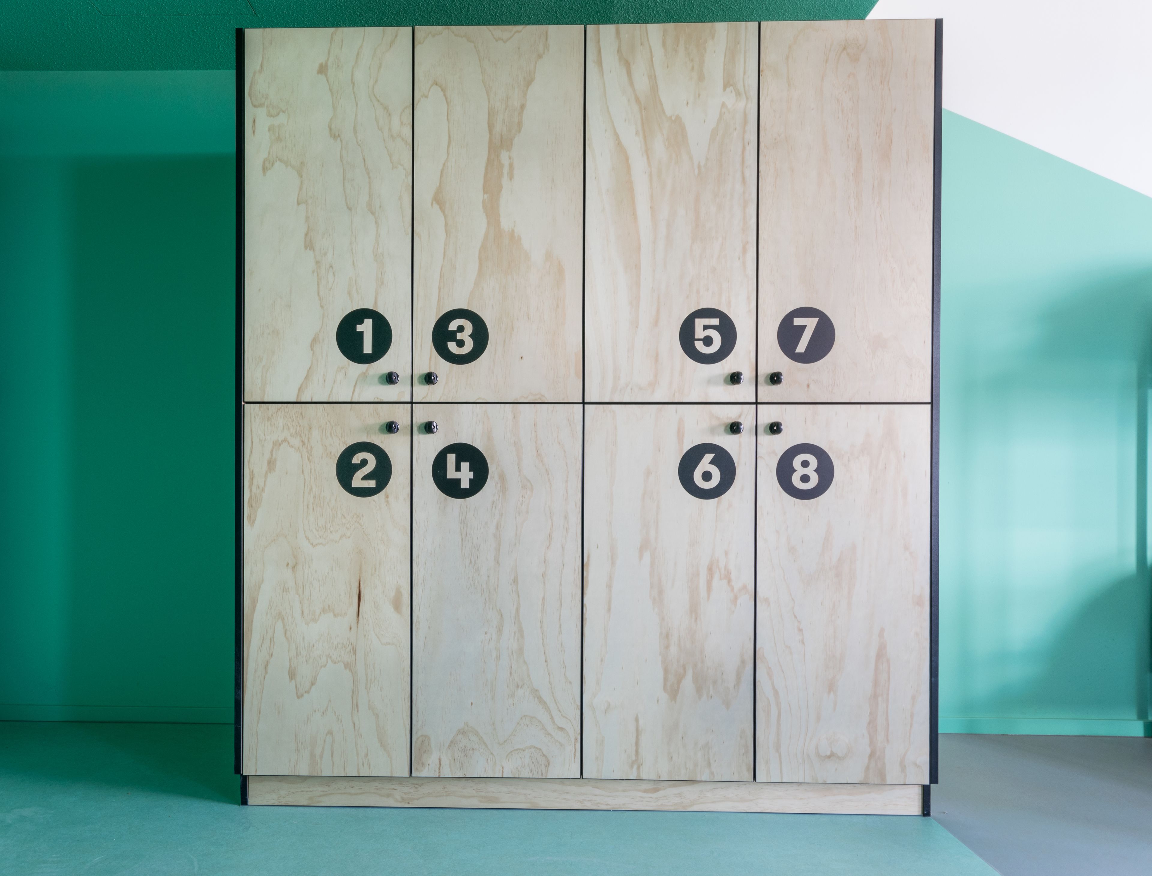 Armário de madeira com quatro painéis e compartimentos numerados, provavelmente usado para guardar ou organizar objetos.