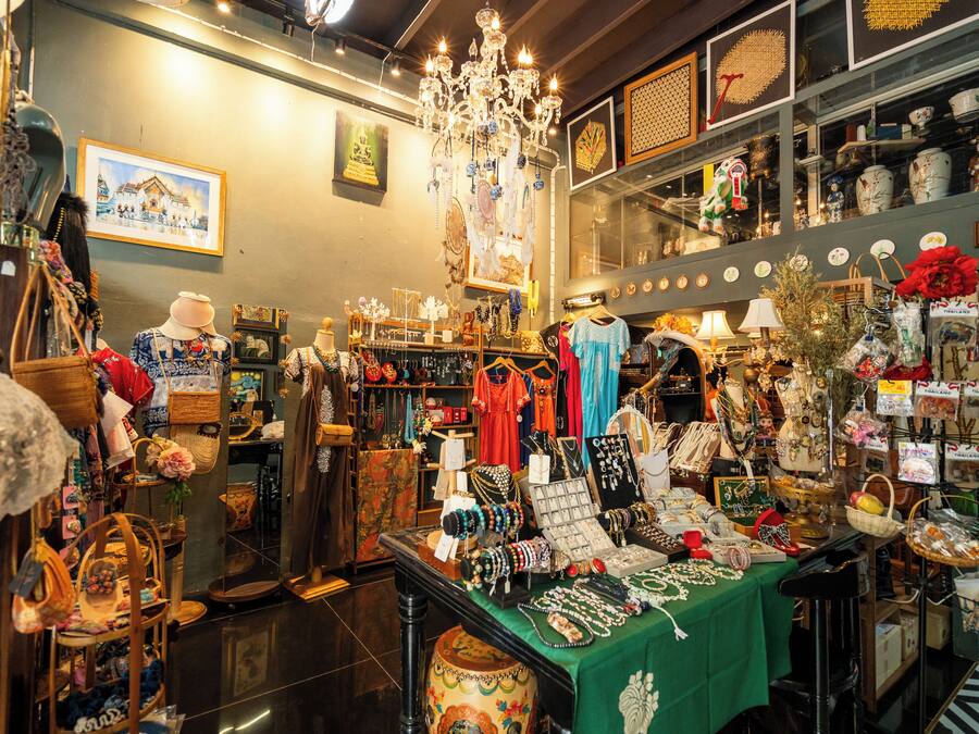 Uma boutique com diversos artigos à mostra, incluindo joias, roupas e objetos decorativos.