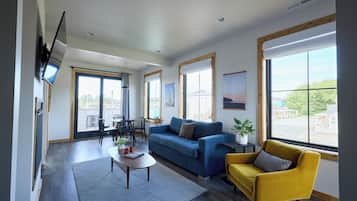 Suíte luxo, 1 quarto, cozinha | Área de estar | TV de tela plana 50 polegadas com canais a cabo, TV, lareira