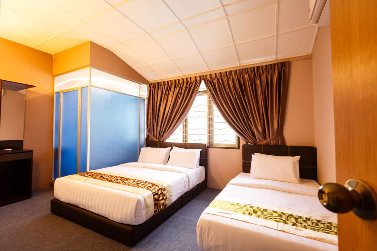 Quarto de hotel com duas camas, televisão e janela com cortinas.