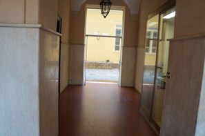 Corredor com porta de vidro que dá para uma área externa.
