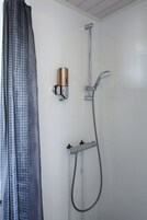 Chuveiro com chuveiro manual e um porta-copos fixado na parede.