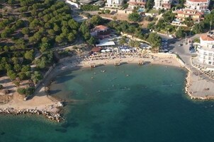 Vista aérea de uma área costeira com praia, barcos e edifícios.