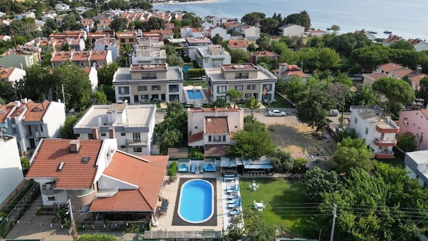 Zona residencial costeira com piscina, vários edifícios e vista para o mar.
