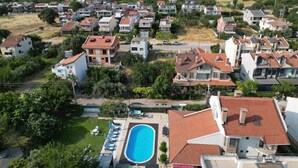 Zona residencial com casas, piscina e vista para o mar.