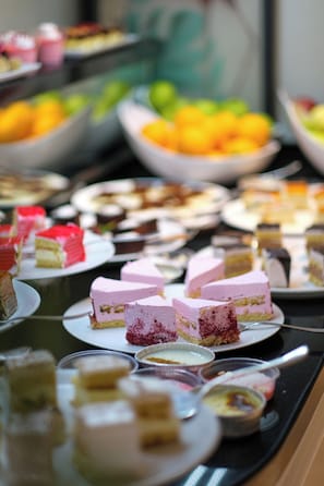 Um buffet com diversos doces e frutas.