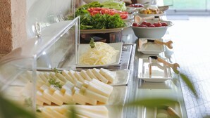 Buffet com diversos alimentos e utensílios.