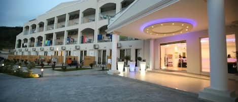 Um hotel com pátio central, várias varandas e entrada bem iluminada.