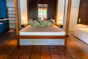 Quarto com estrutura de cama de madeira, janela com vista e escada encostada à parede.