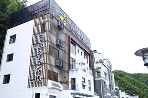 Um edifício moderno com ripas verticais de madeira e uma placa com caracteres chineses.