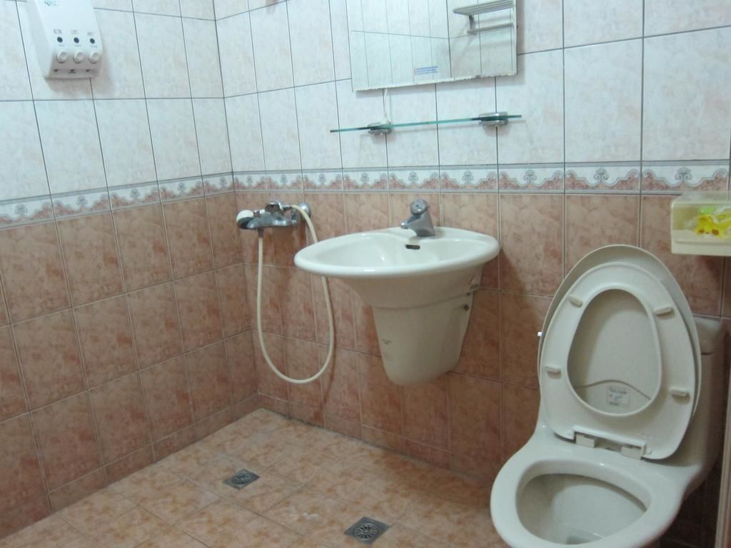 Um banheiro pequeno com vaso sanitário, pia e chuveiro.