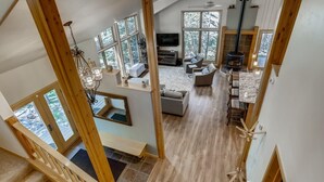 Um loft espaçoso com pé direito alto, janelas amplas, lareira e área de refeições.