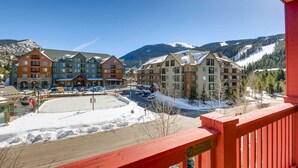 Um hotel com vários edifícios, área de estacionamento e montanhas nevadas ao fundo.
