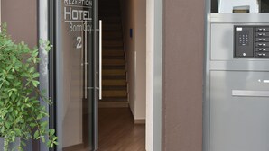 Uma área de recepção com porta de vidro identificada com a placa "RECEPTION HOTEL Bonn City 2".
