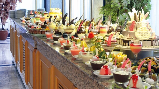 Buffet com diversos doces e bebidas.