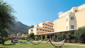 Um hotel com vários andares, áreas de estar ao ar livre e um pátio gramado.
