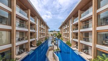 Um hotel moderno com piscina central, várias varandas e áreas de estar ao ar livre.