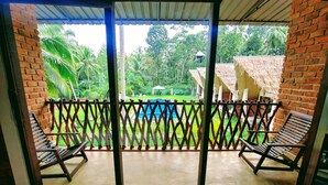 Uma varanda com vista para uma piscina e vegetação exuberante.