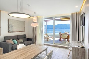 Suíte luxo, 2 quartos, sacada, vista para o mar | Área de estar | TV de tela plana