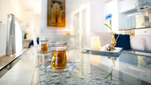 Interior moderno com uma mesa de vidro exibindo um conjunto de chá e uma vela.